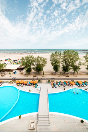 Uma área de piscina com vista para a praia e para o oceano.