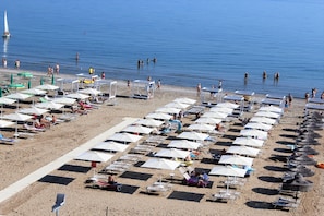 Praia particular, espreguiçadeiras, guarda-sóis 
