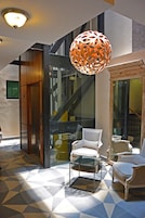 Um interior moderno com piso estampado geométrico, uma escada e móveis contemporâneos.
