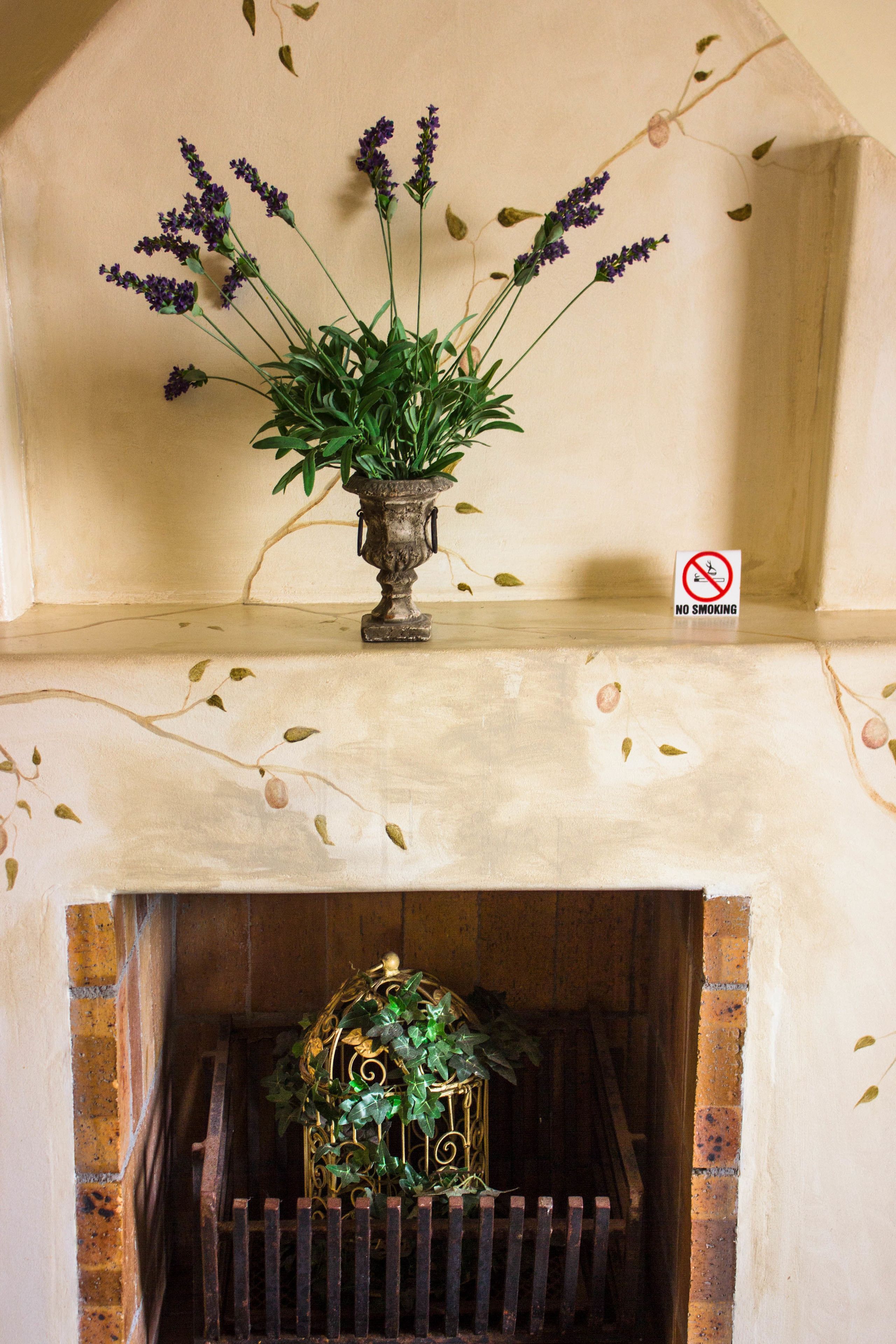 Lareira com design floral e aviso de proibido fumar.