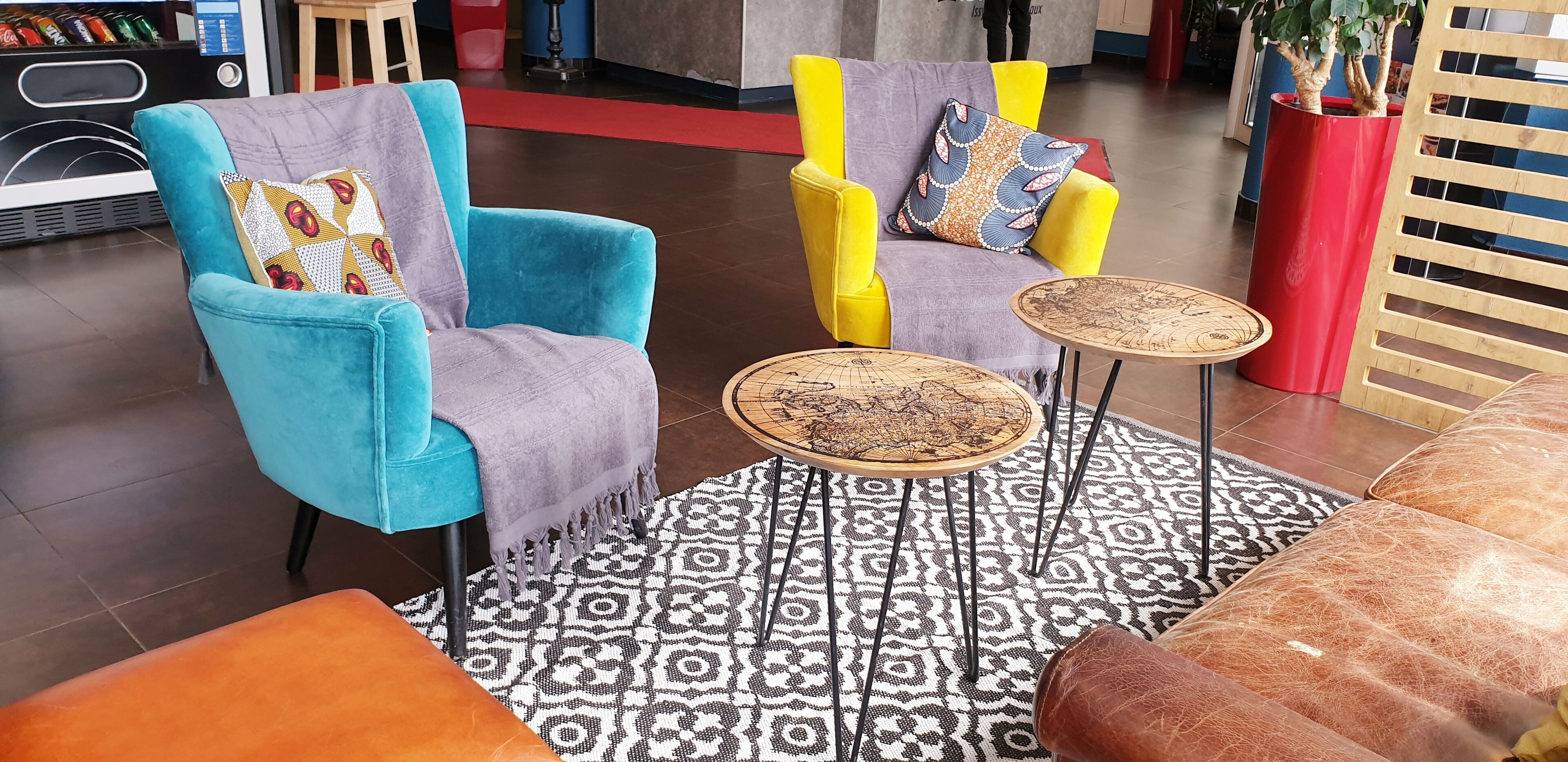 Uma área de estar moderna com duas poltronas, uma mesinha redonda e um tapete estampado.