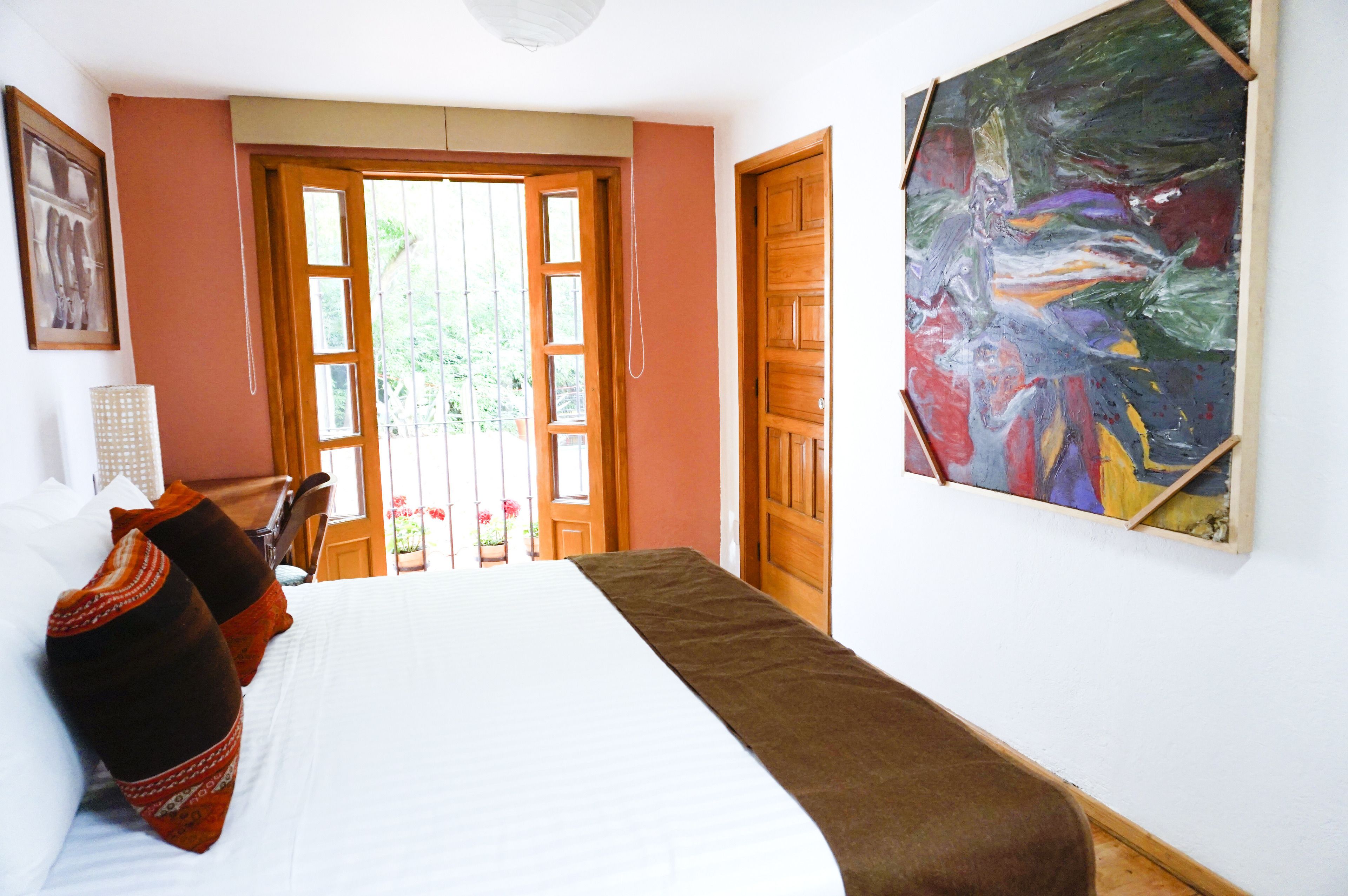 Quarto de hotel com uma cama, um quadro e vista para o exterior.