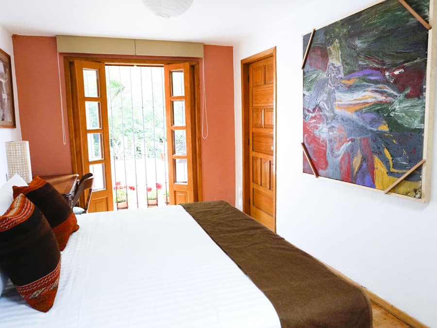 Quarto de hotel com uma cama, um quadro e vista para o exterior.