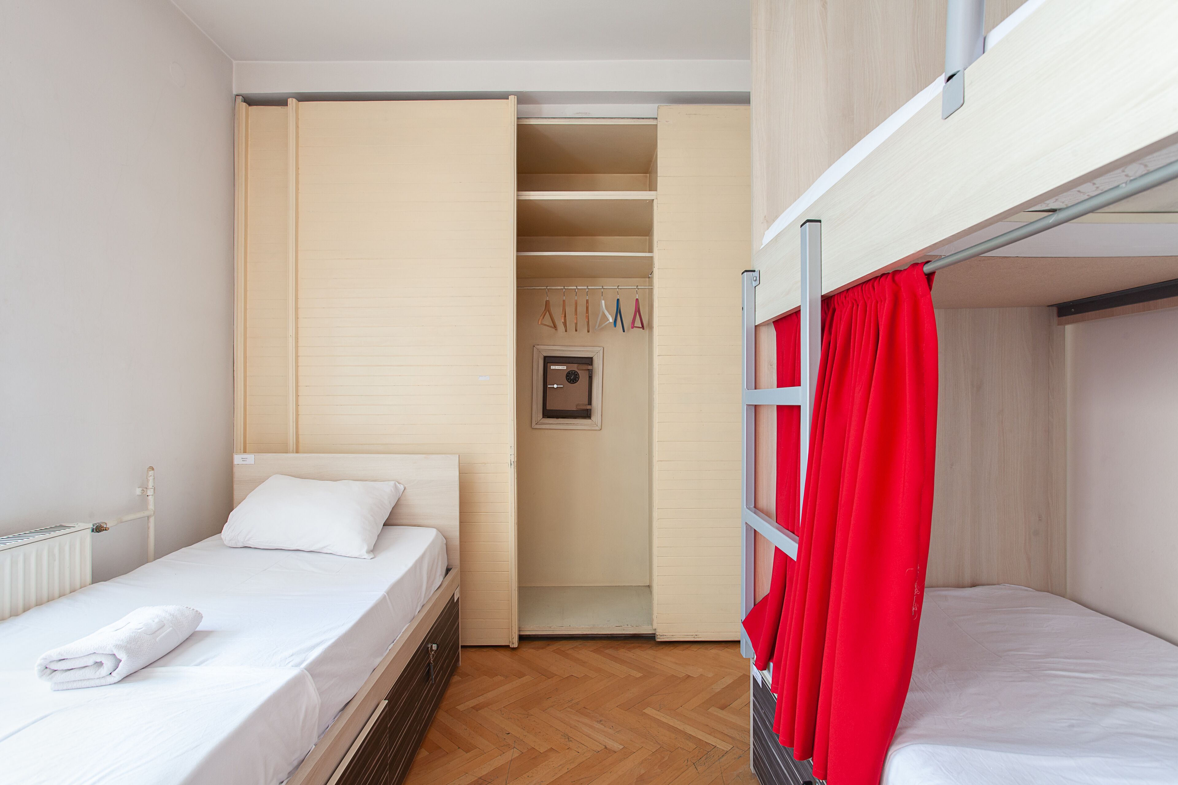 Quarto com uma cama de solteiro, uma cama beliche e um guarda-roupa.