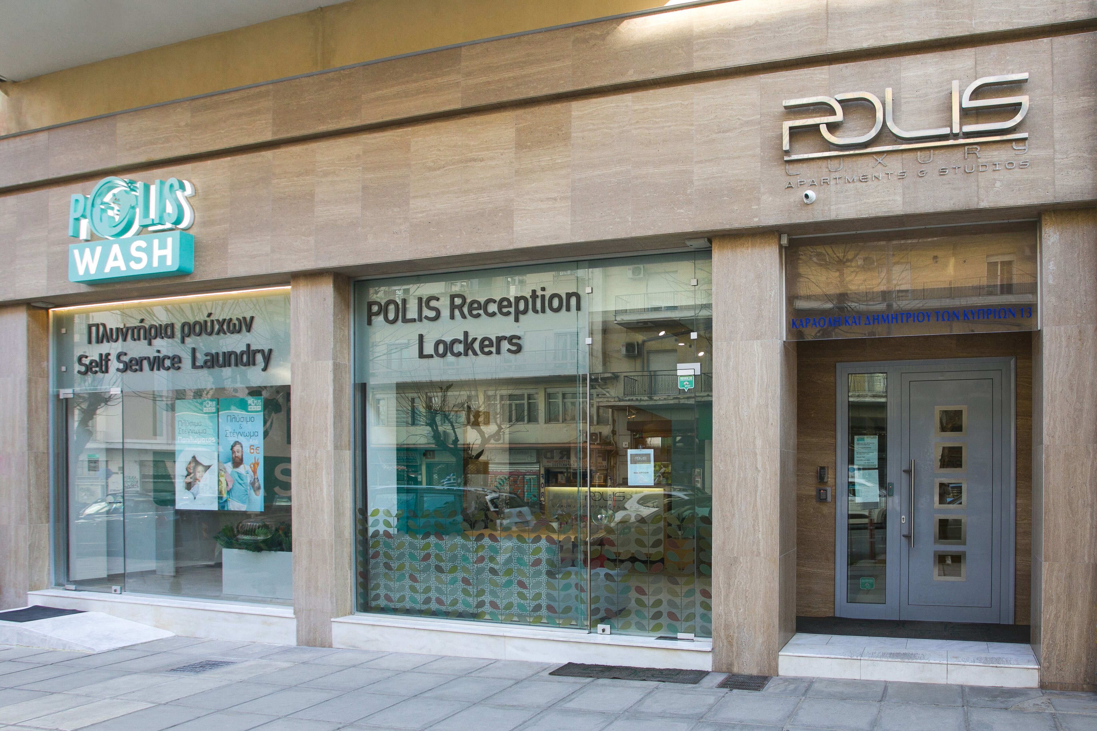 Um edifício com uma placa POLIS Reception Lockers e uma placa POLIS WASH Self Service Laundry.