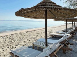 Na praia, espreguiçadeiras, guarda-sóis de praia 