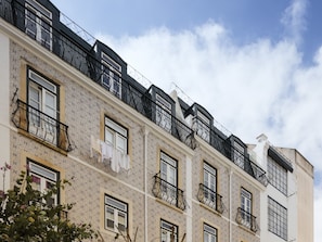 Um edifício de vários andares com varandas, janelas e fachada revestida de azulejos.
