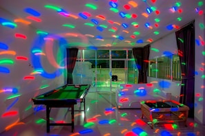 Quarto com mesa de bilhar, sofá e poltrona.