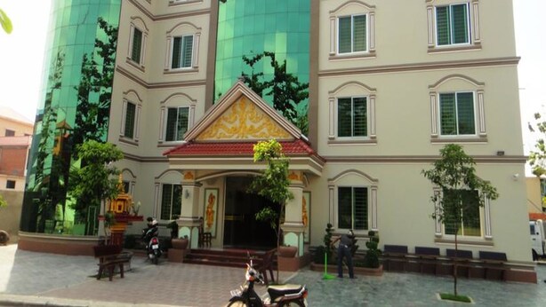 Hotel de vários andares com estilo arquitetônico tradicional, apresentando uma entrada central com arco decorativo e telhado com telhas.
