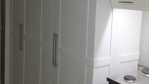 Uma cozinha com armários brancos, bancada preta e forno embutido.