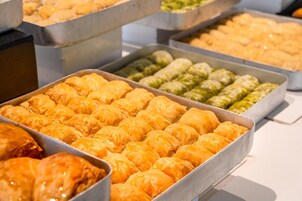 Diversos doces e pastelaria dispostos em bandejas.