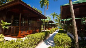 Resort com construções de madeira, um caminho e vegetação exuberante.