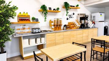 Uma cozinha moderna com armários de madeira, um espaço para café e uma área de refeições com mesas e cadeiras.