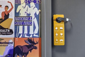 Uma porta com suporte para cartão-chave amarelo exibindo serviços e comodidades do hotel.