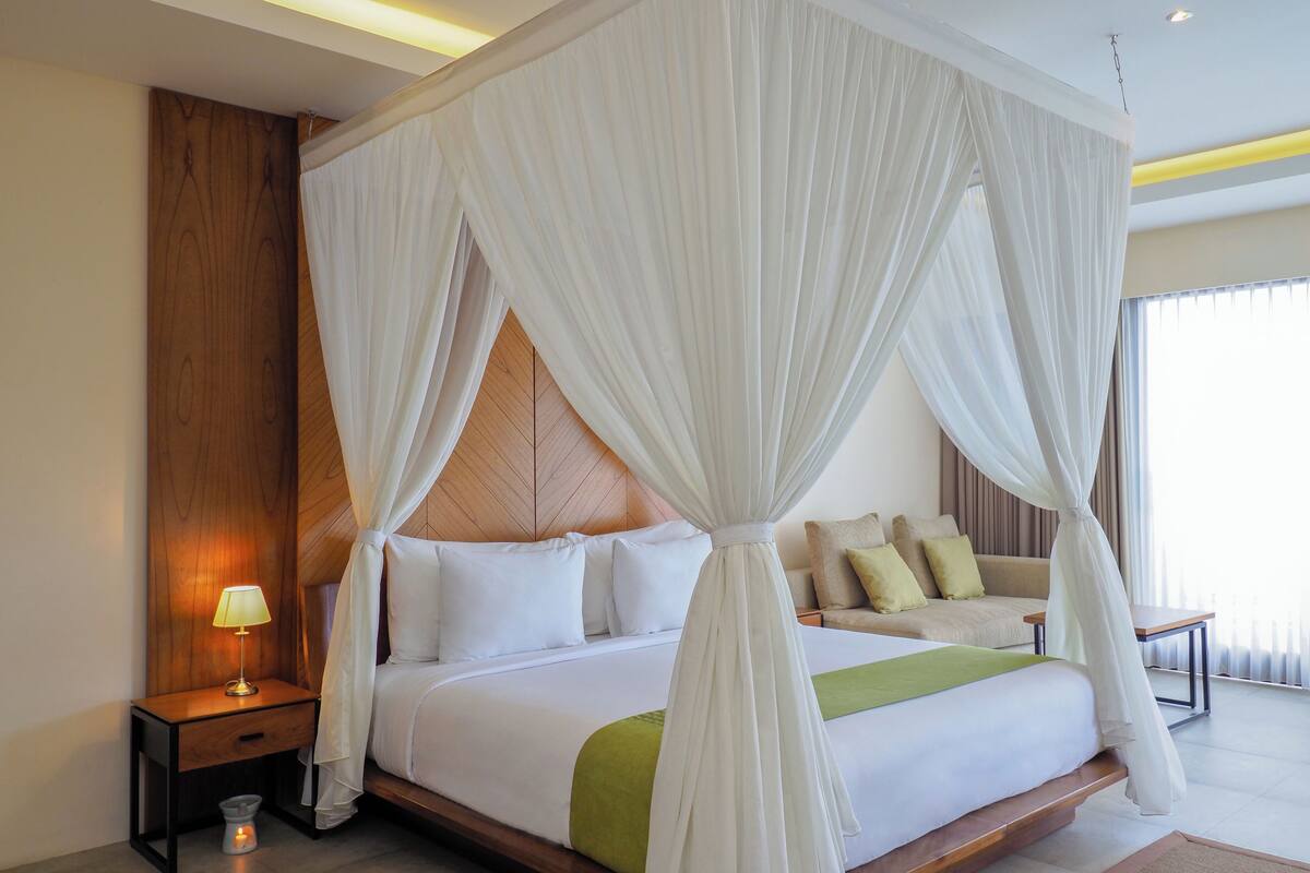 Um quarto espaçoso com uma cama grande, uma mesa de cabeceira e um criado-mudo.