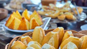 Buffet com diversos alimentos, incluindo pães e itens fritos.