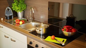 Uma cozinha com pia, fogão e diversos utensílios de cozinha.