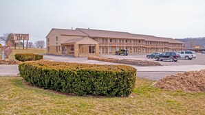 Um motel com um prédio central e estacionamento.