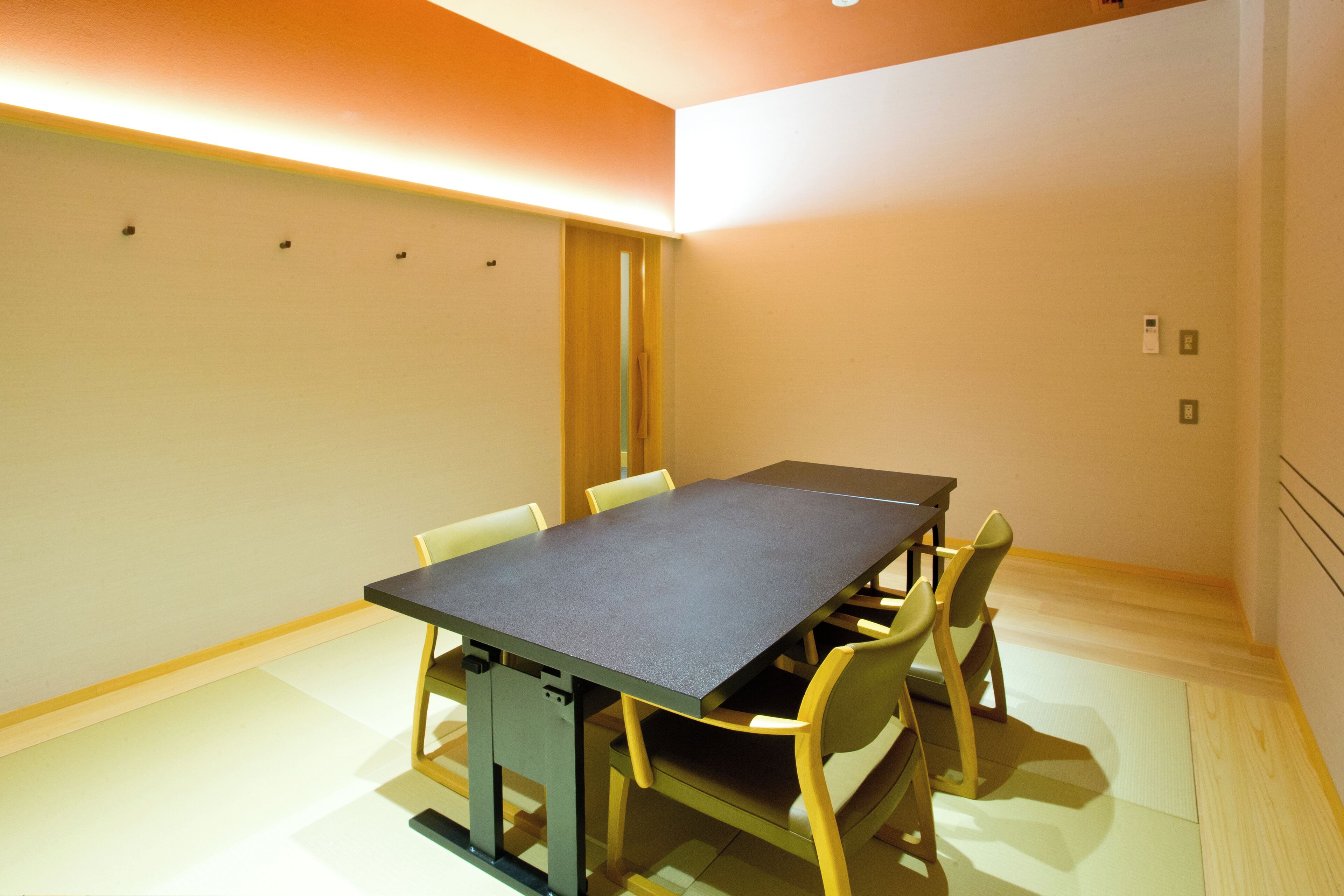 Uma sala de conferências com uma mesa retangular e seis cadeiras.