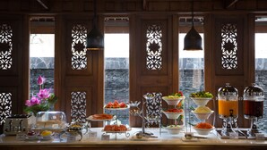 Disposição de buffet com diversos alimentos e um canto para café.
