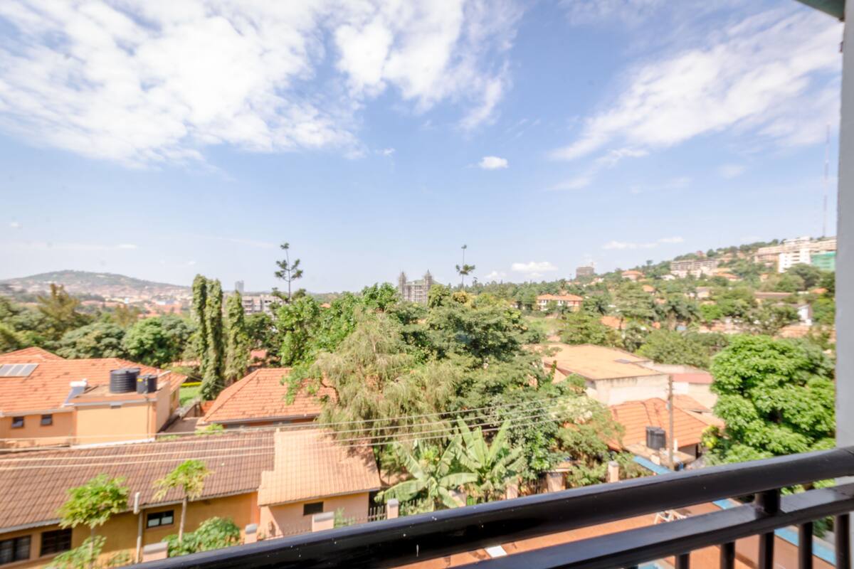 Bairro residencial com casas, árvores e céu claro.