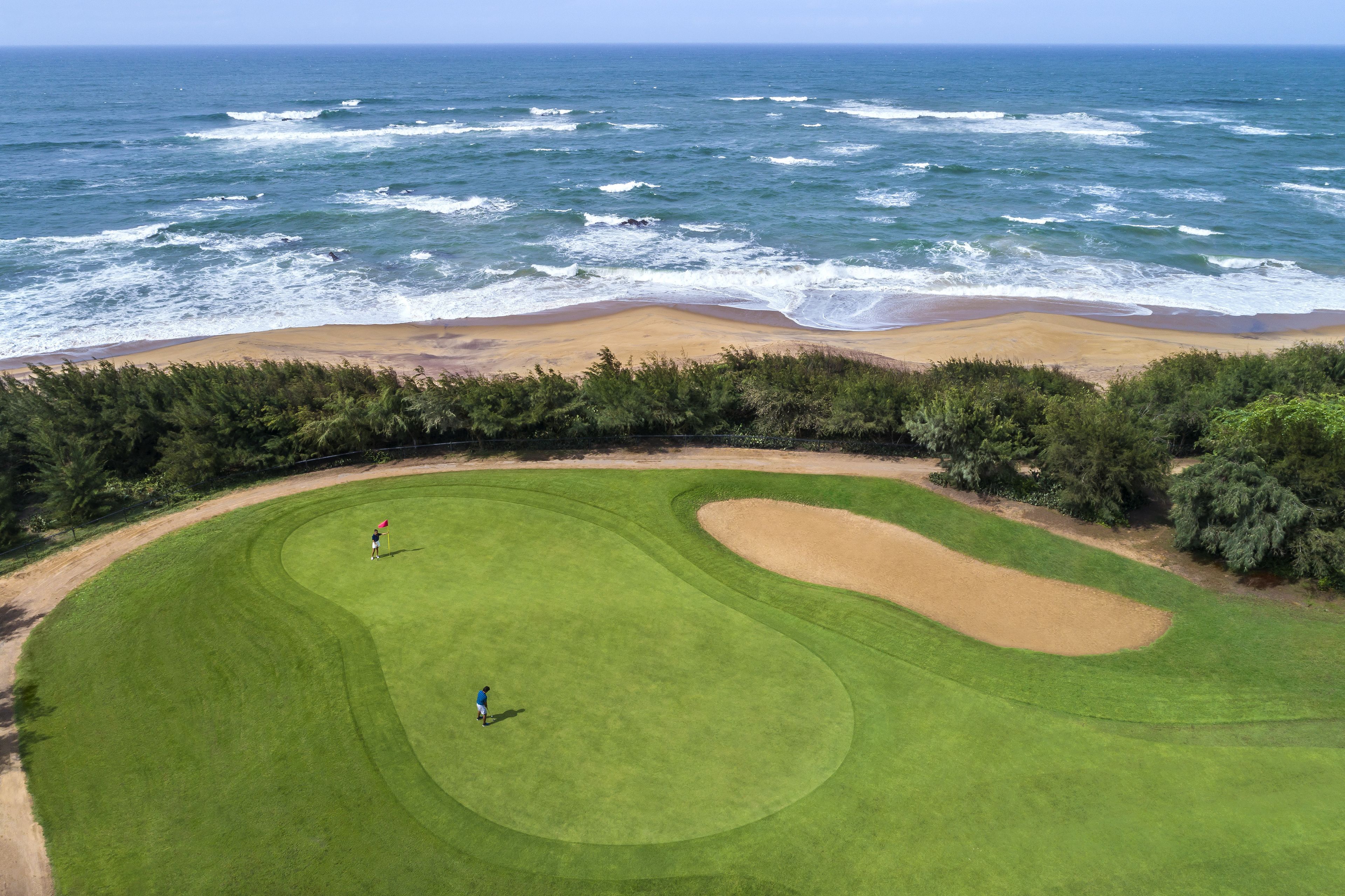 Um campo de golfe com vista para o oceano.