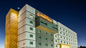 Um hotel com design moderno, exibindo uma placa chamativa 'Hotel Express' e uma fachada dourada marcante.