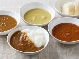 Uma mesa com tigelas de comida, incluindo arroz e diversos pratos.