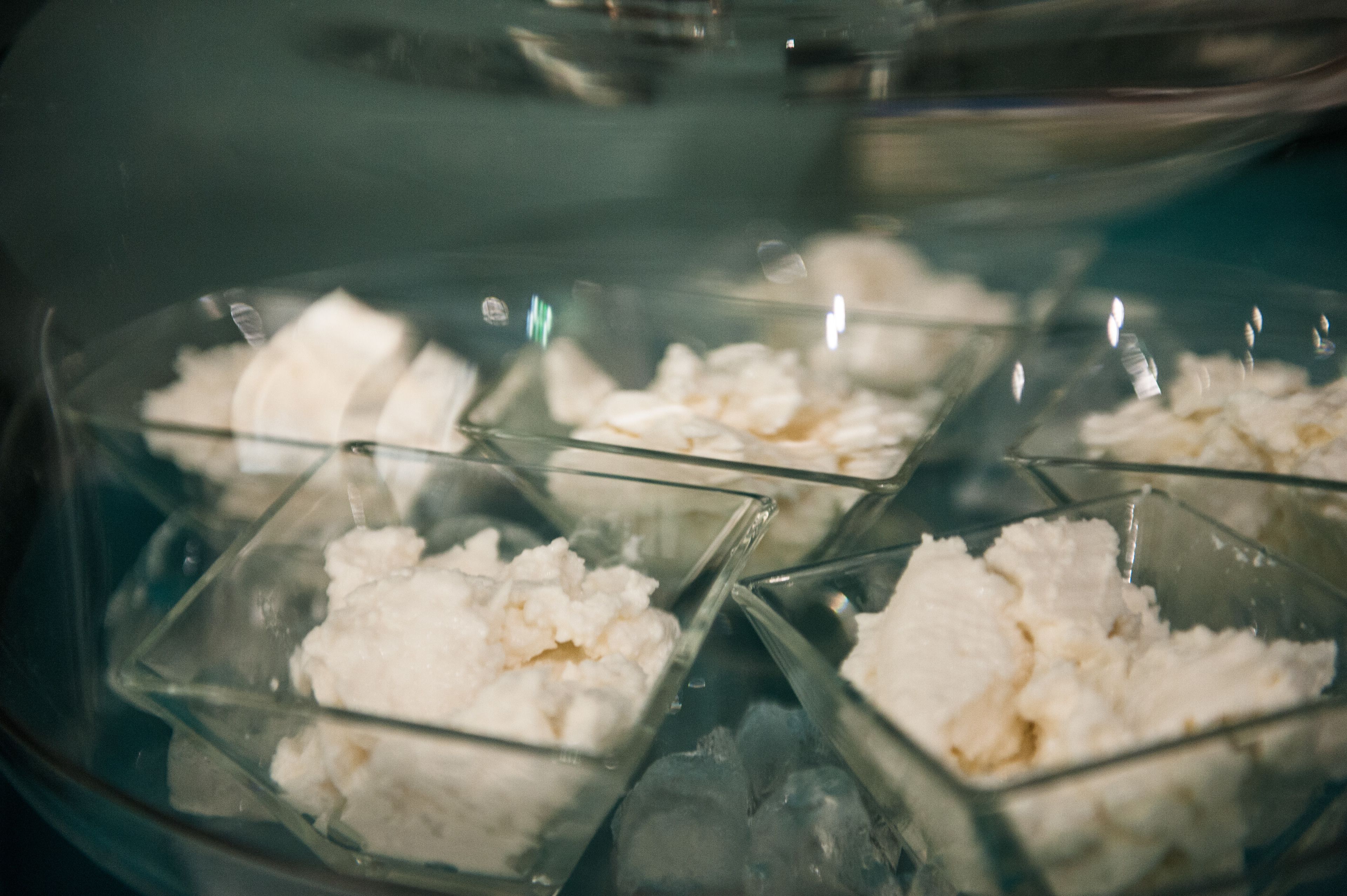 Vitrine de vidro com cubos de gelo e cubos brancos, provavelmente queijo ou um alimento parecido.