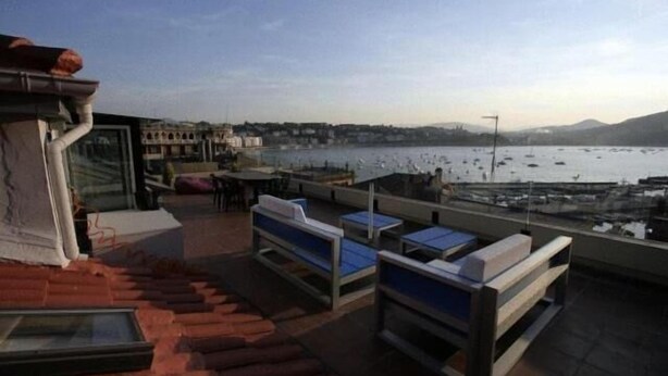 Terraço no telhado com área de estar e vista para o mar.