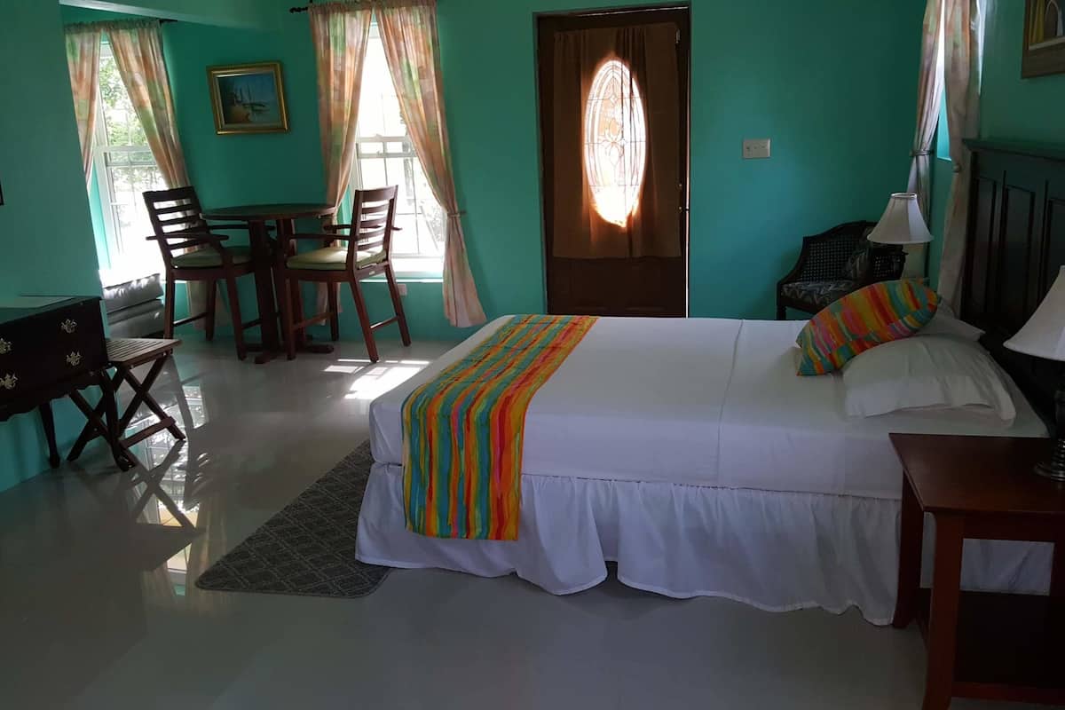 Um quarto com cama, escrivaninha e cadeira.