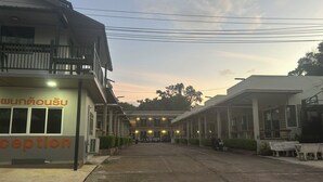 Uma área de recepção de hotel com varanda, galeria coberta e estacionamento.