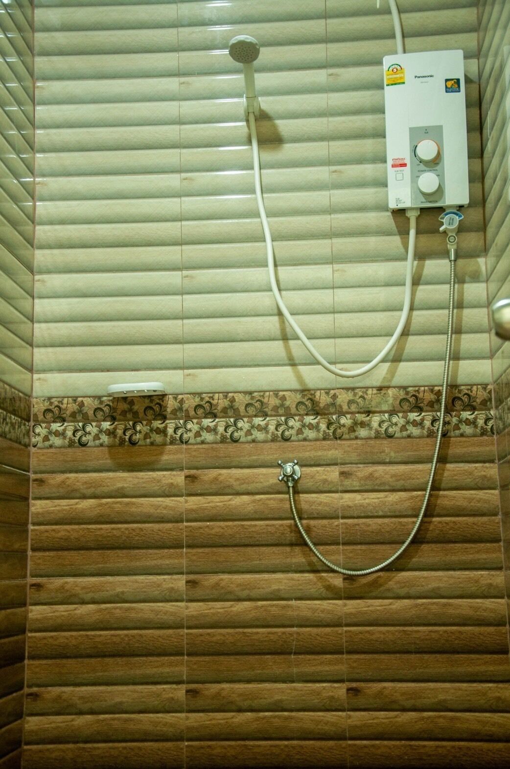 Uma casa de banho com cabine de duche, painel de controlo e chuveiro.