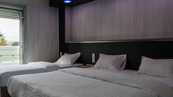 Quarto de hotel moderno com duas camas, uma janela grande e teto escuro com iluminação embutida.
