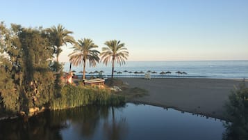 Na praia, espreguiçadeiras, guarda-sóis, toalhas de praia