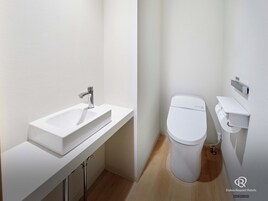 Uma casa de banho moderna com uma sanita, lavatório branco e torneira cromada.