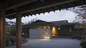 Uma casa moderna com garagem coberta, garagem e um jardim bem cuidado.