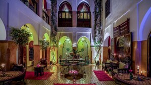 Interior com uma fonte central, áreas de estar e arcos.