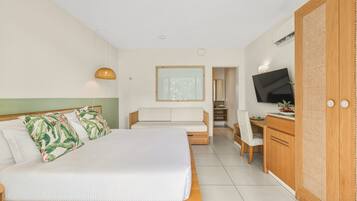 Quarto moderno com uma cama grande, escrivaninha, televisão e guarda-roupa.