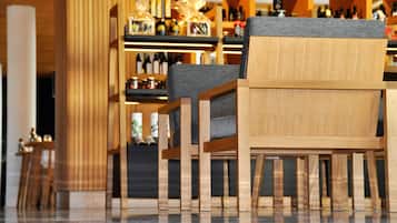 Decoração moderna com mobiliário de madeira e um espaço bar com prateleiras cheias de garrafas.