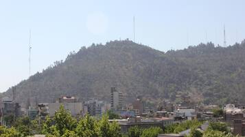 Paisagem urbana com edifícios e uma colina ao fundo.