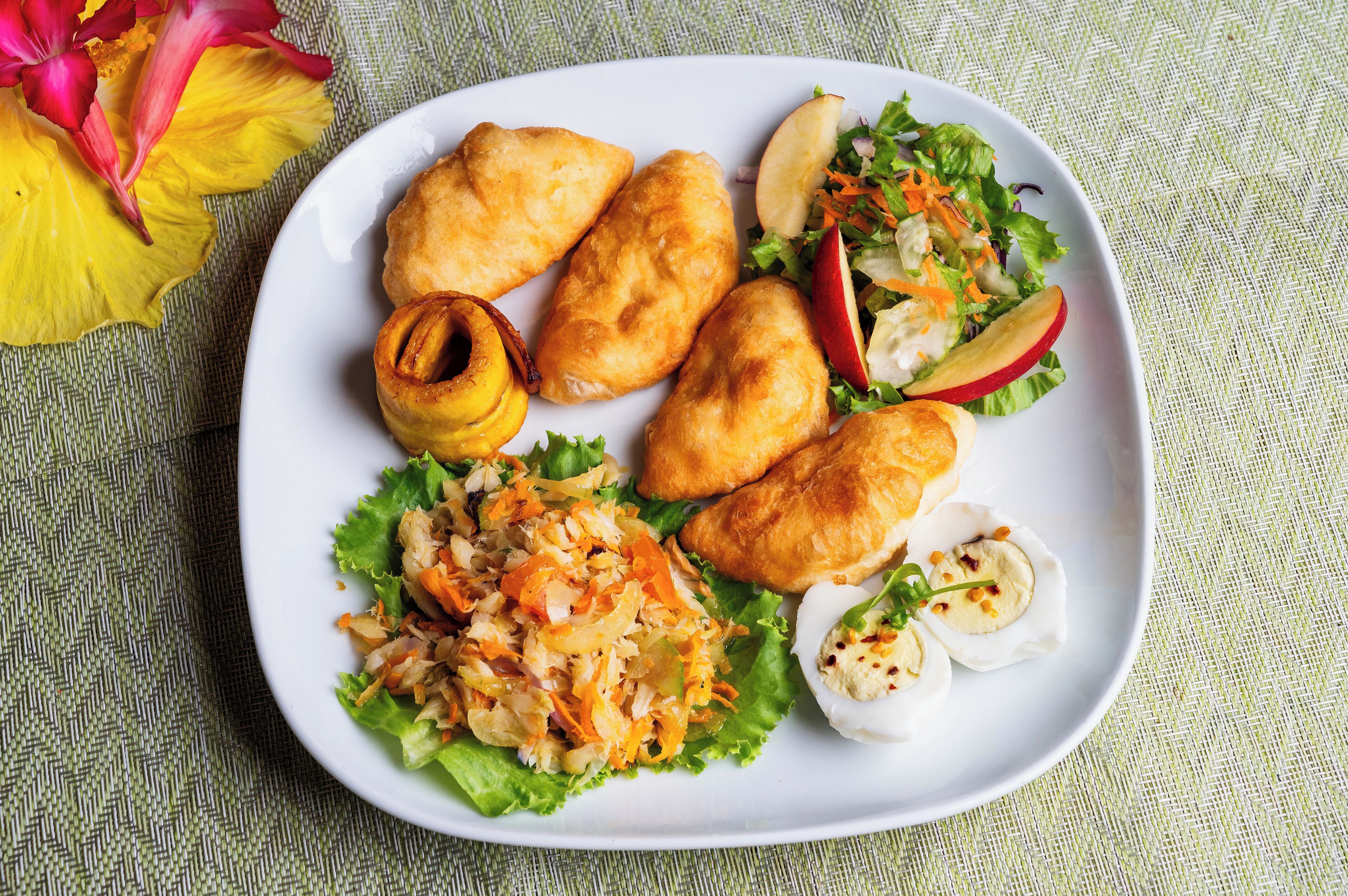 Prato com alimentos fritos, salada e ovos cozidos.