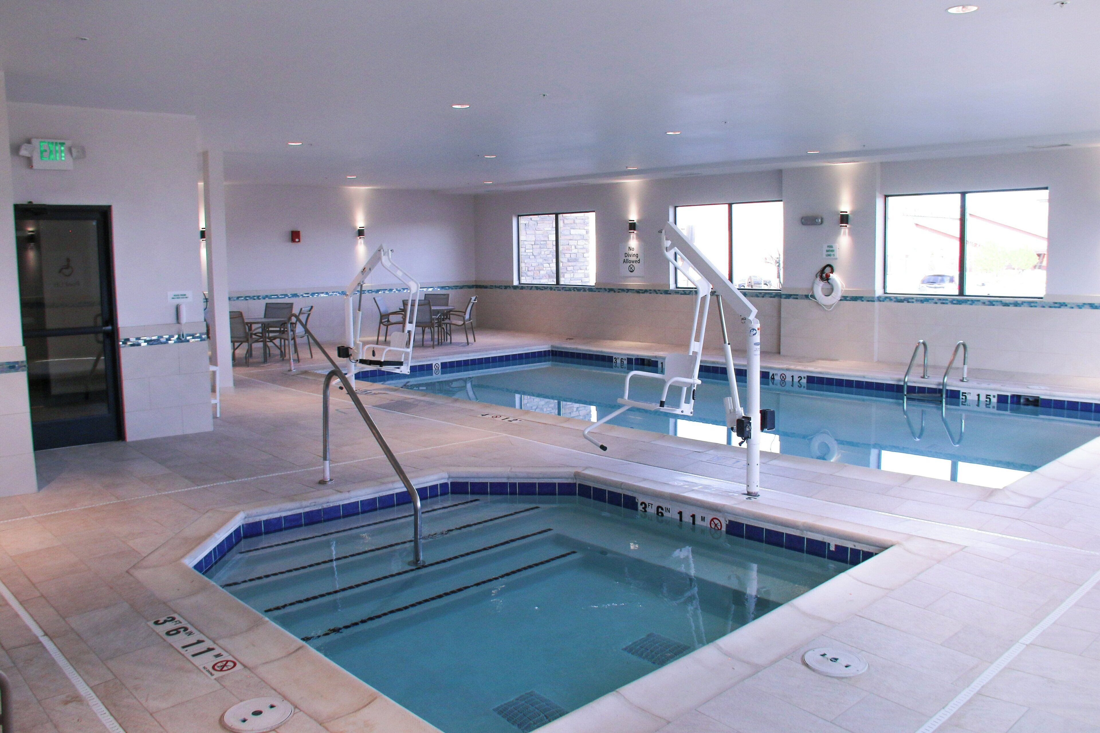 Área de piscina com várias pistas, sala de trocas e espaço para sentar.