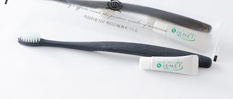 Uma escova de dentes e sua embalagem com texto em inglês e japonês.