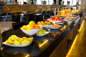 Buffet com diversas frutas e pratos.