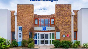 A brick building with a sign reading "ibis budget" and another sign below it that says "Rennes Chantepie."