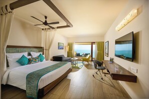 Quarto de hotel com cama, escrivaninha, cadeira, televisão e varanda com vista.