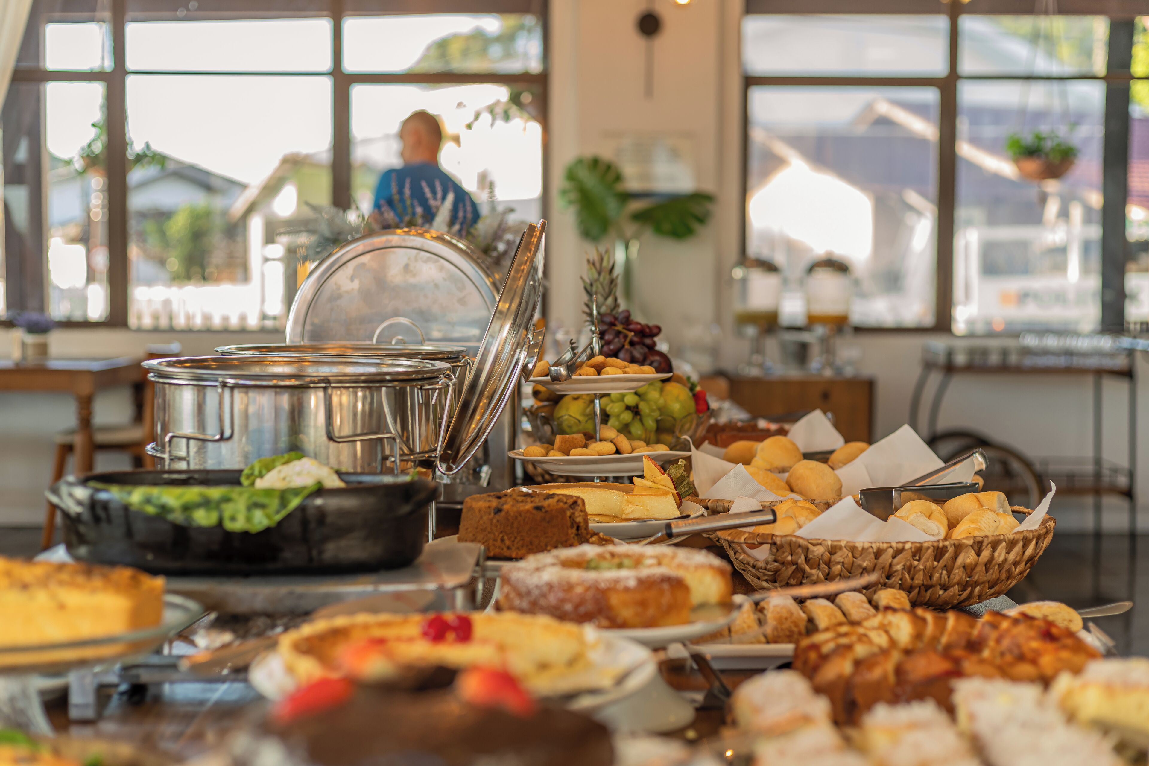 Buffet com diversos alimentos, incluindo frutas, doces e um bolo grande.