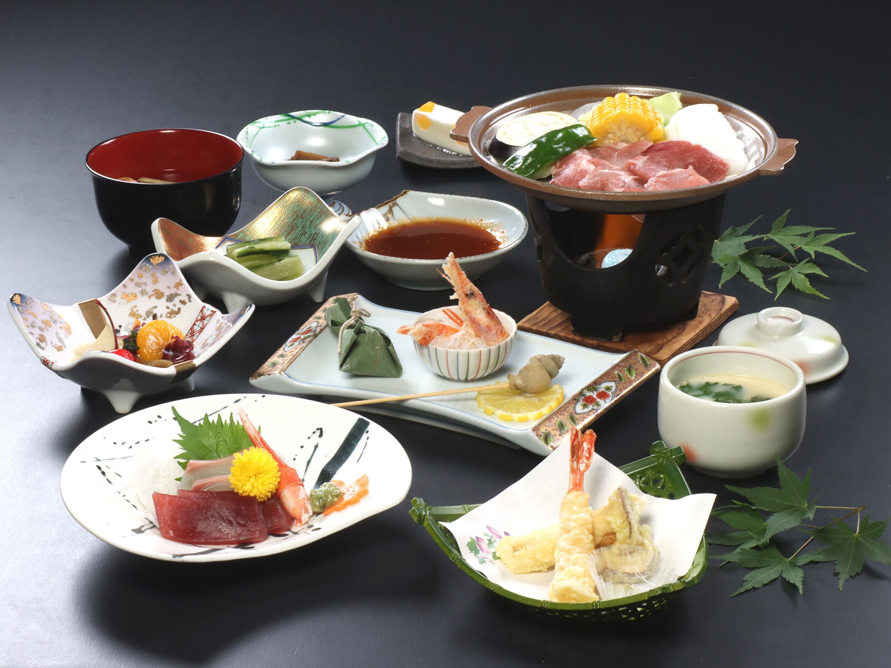 Diversos pratos japoneses, incluindo sashimi, tempura e um cozido.