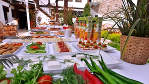 Uma mesa de buffet com diversos alimentos e vegetais frescos.